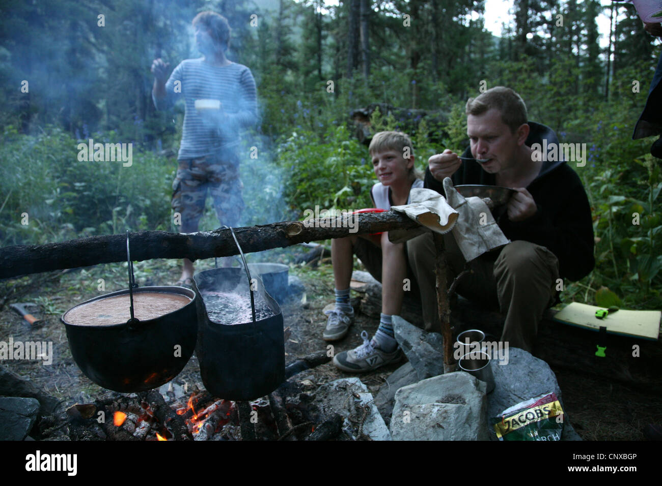 Tourists cooking on the campfire during a trekking in the Altai ...