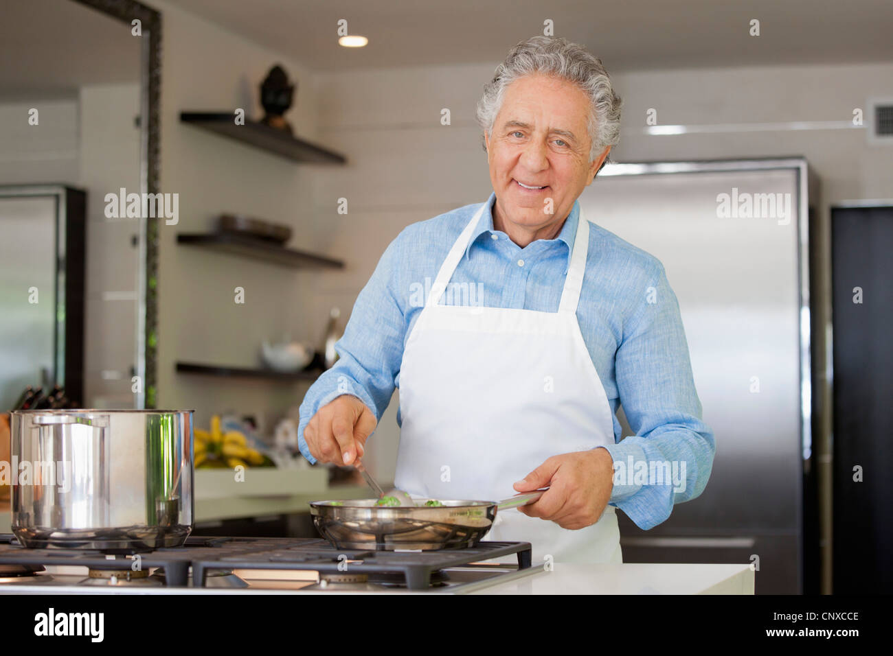 A cheerful man cooking in a domestic kitchen Stock Photo - Alamy