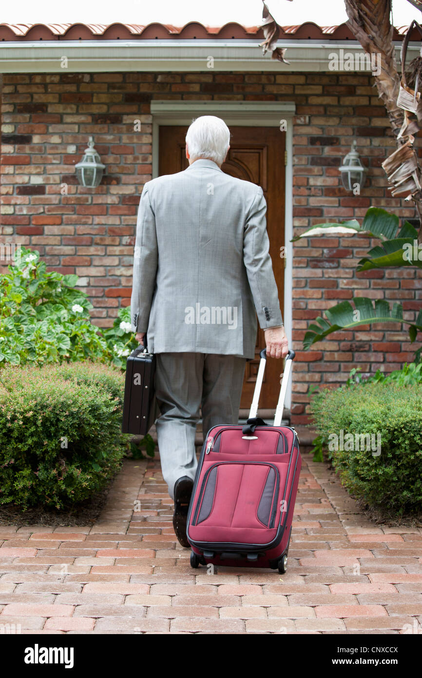 A businessman arriving home from a trip Stock Photo - Alamy