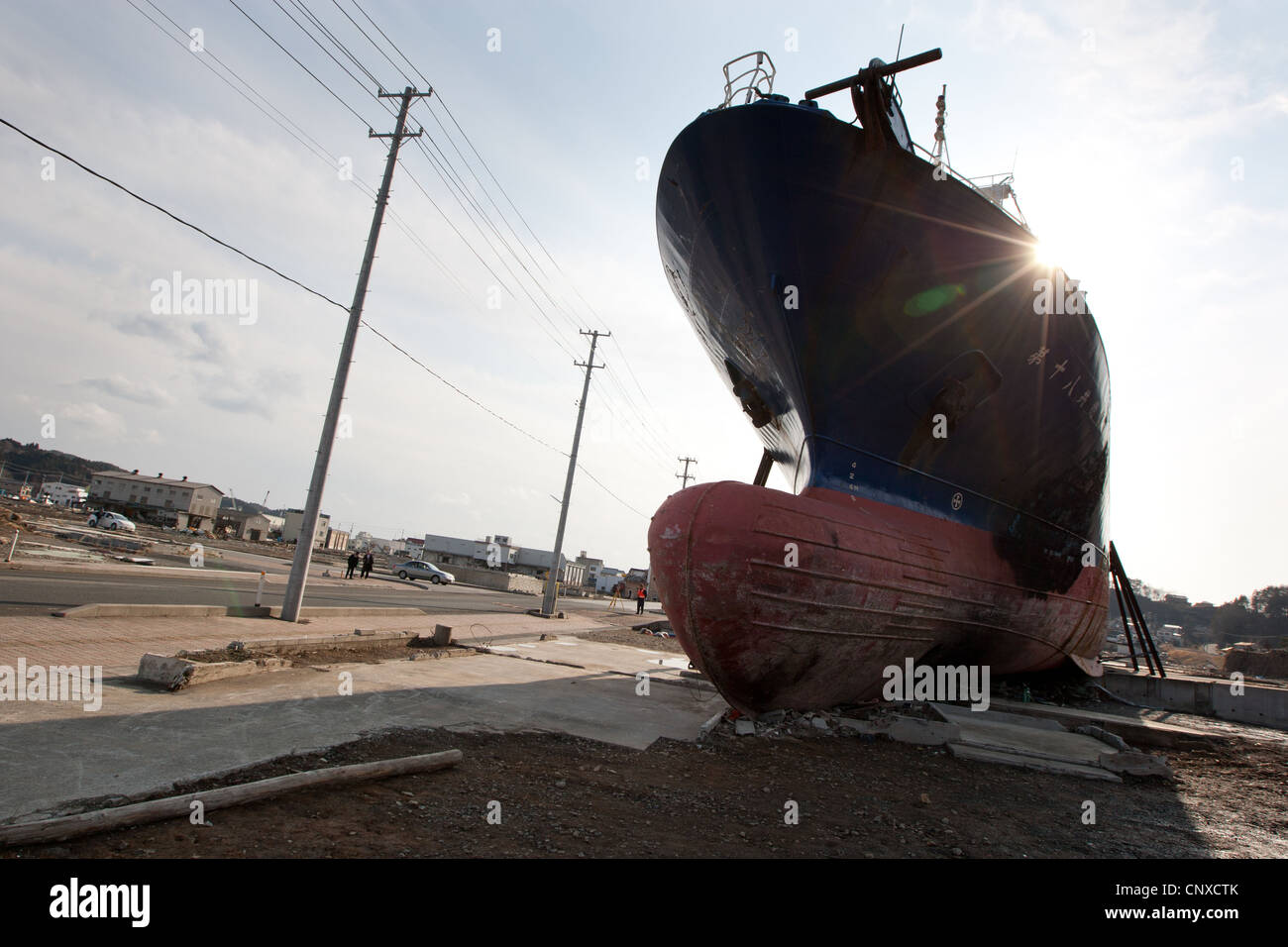 large fishing vessel sits stranded on land, after being carried inland ...