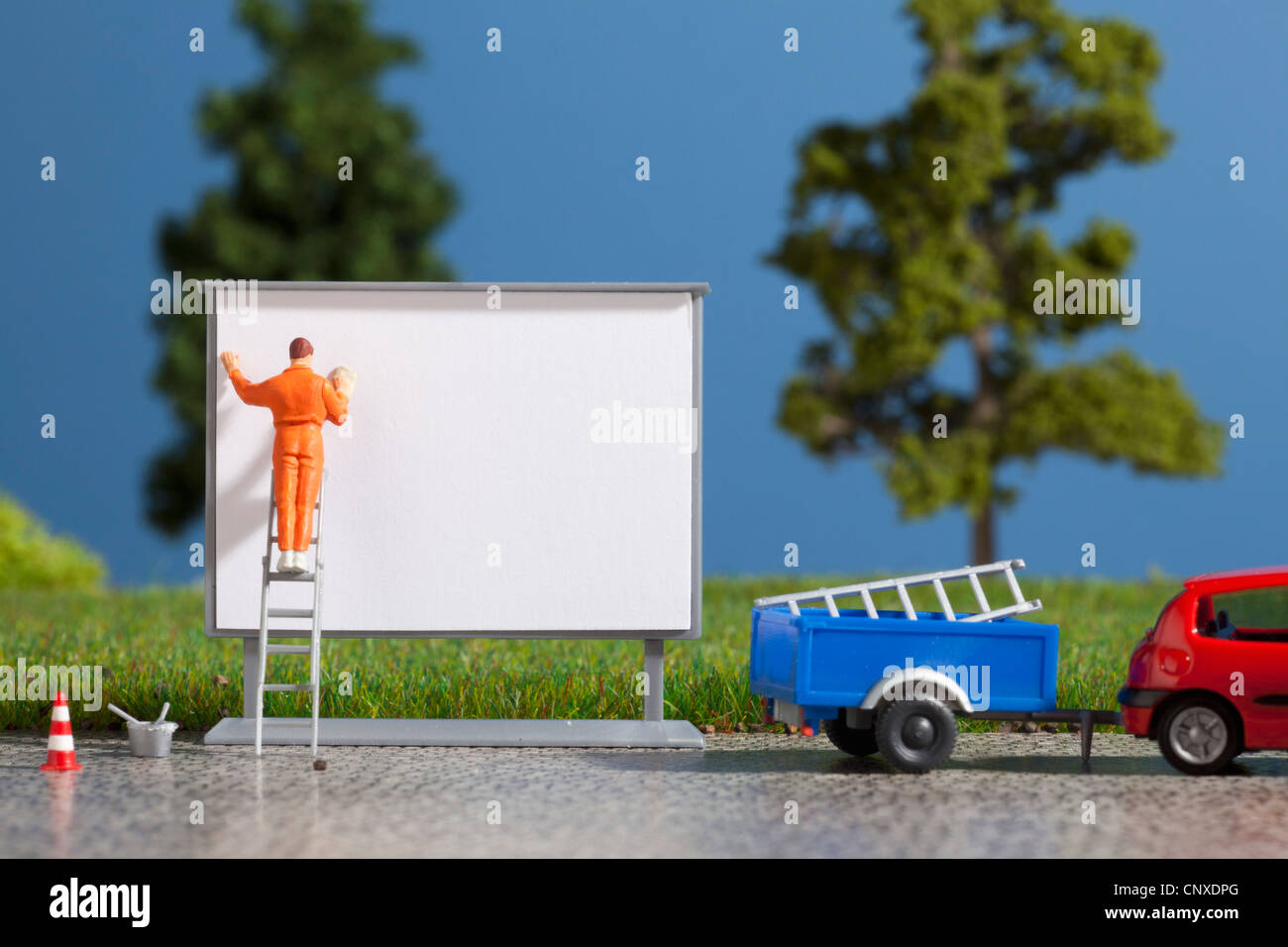 A diorama of a miniature worker billboard posting Stock Photo - Alamy