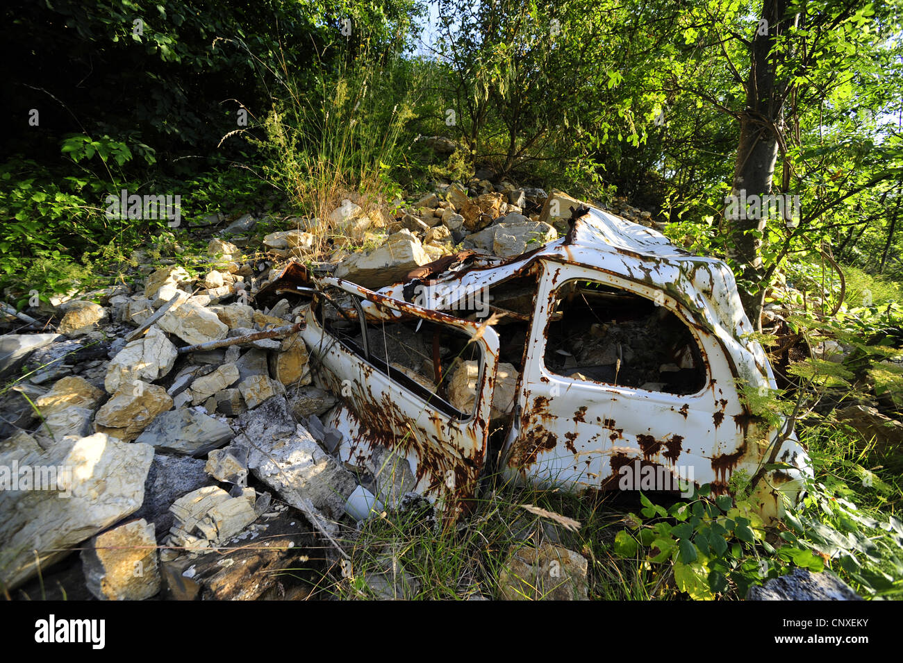 rusty car wreck and boulders, Italy, Liguria Stock Photo - Alamy