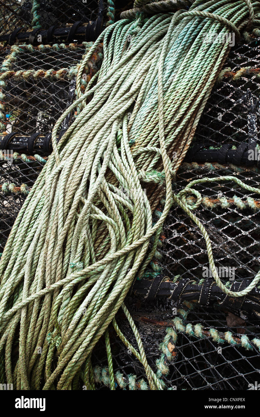 Coils of rope lie over a stack of lobster pots on the quay at Boscastle ...