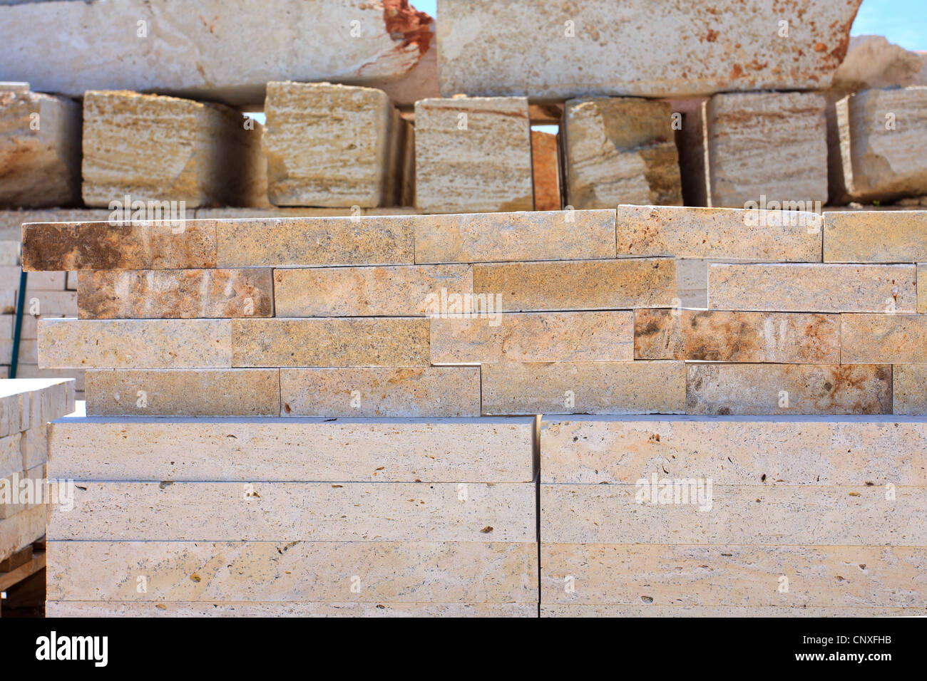 blocks of limestone processed and ready for use, are against the blue ...