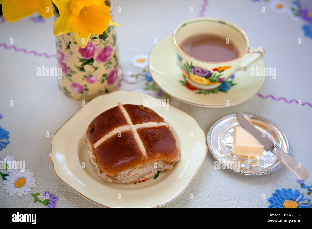 A Hot Cross Bun served on a vintage china plate with a cup of English ...