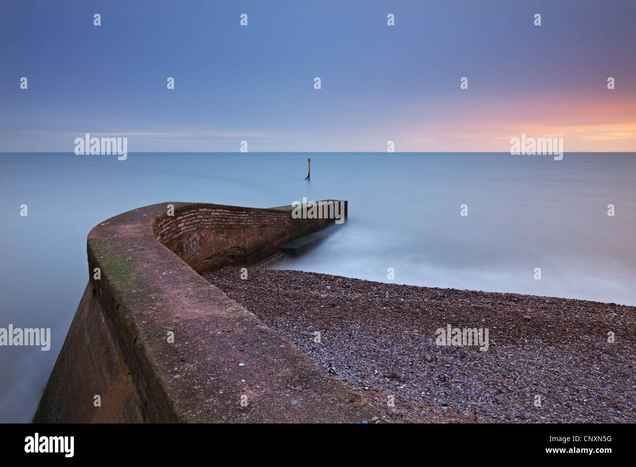 Stone jetty on Sidmouth beachfront at sunset, Sidmouth, Devon, England ...