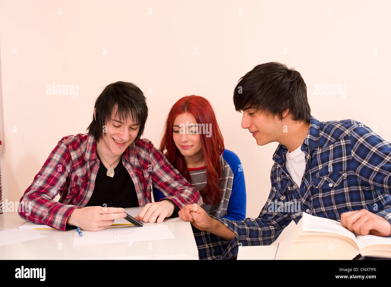 Three classmates using a smartphone Stock Photo - Alamy