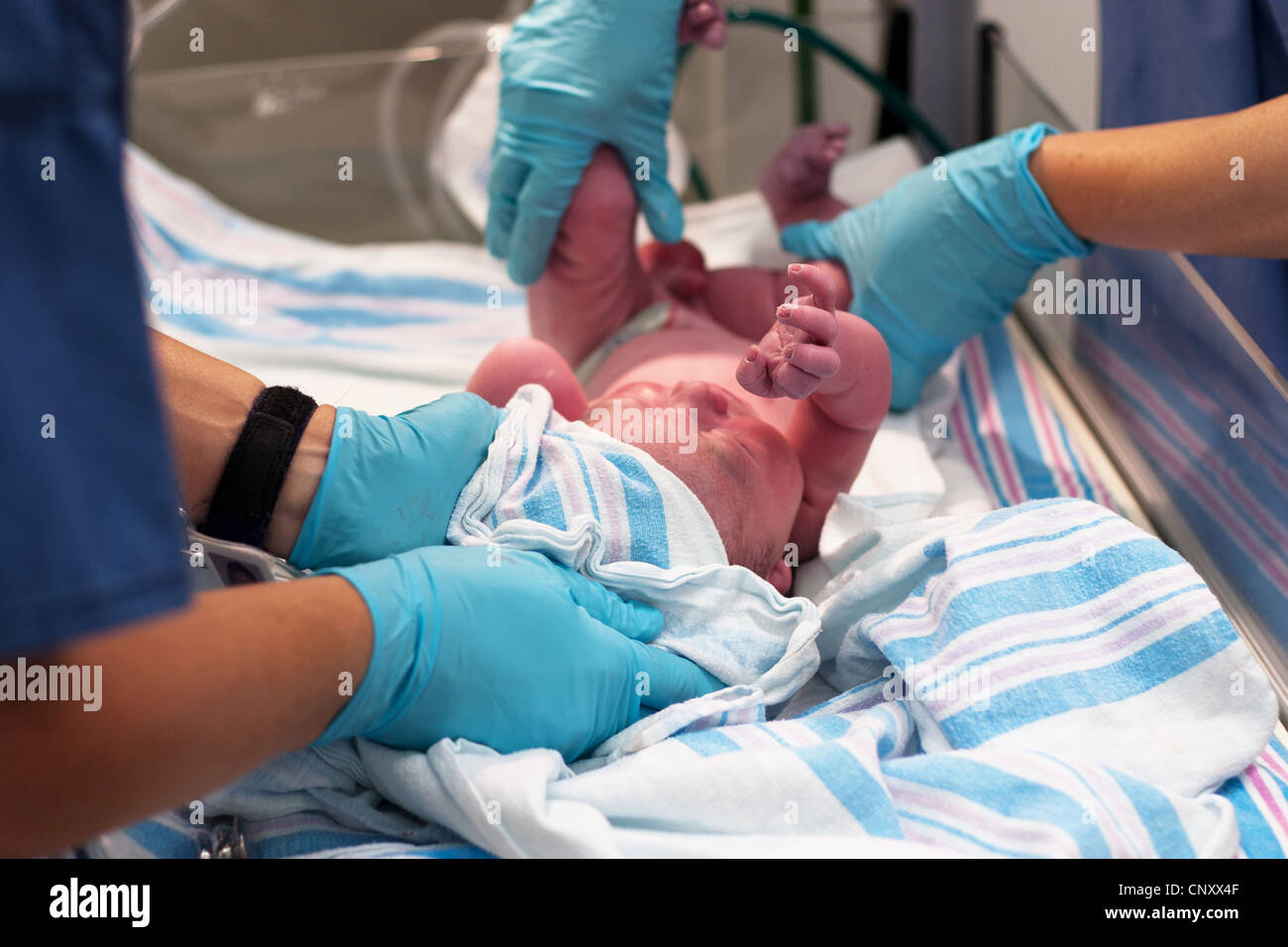Nurses cleaning off baby immediately after birth Stock Photo - Alamy