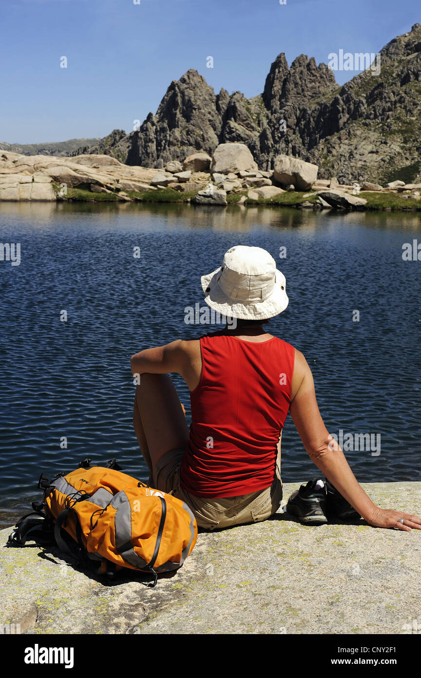 female wanderer sitting at Rinoso lake and resting, France, Corsica ...