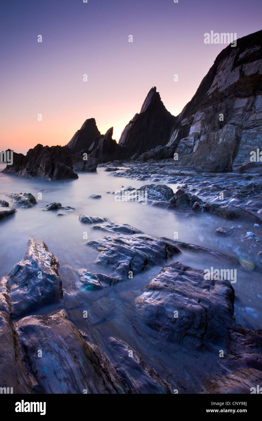 Twilight on the secluded rocky cove at Westcombe Beach, South Devon ...