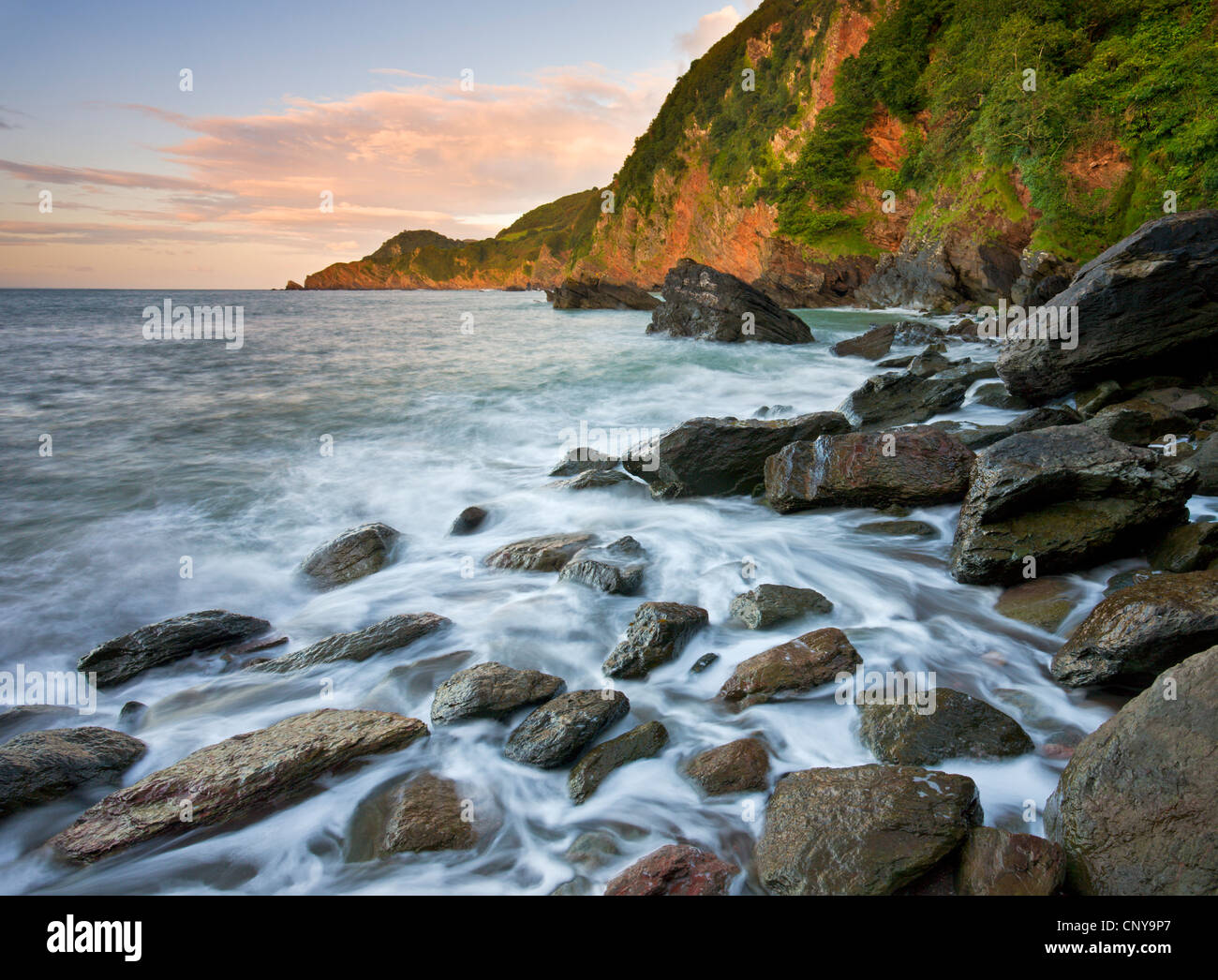 Waves crash around the rocky shores of Woody Bay at high tide, Exmoor ...