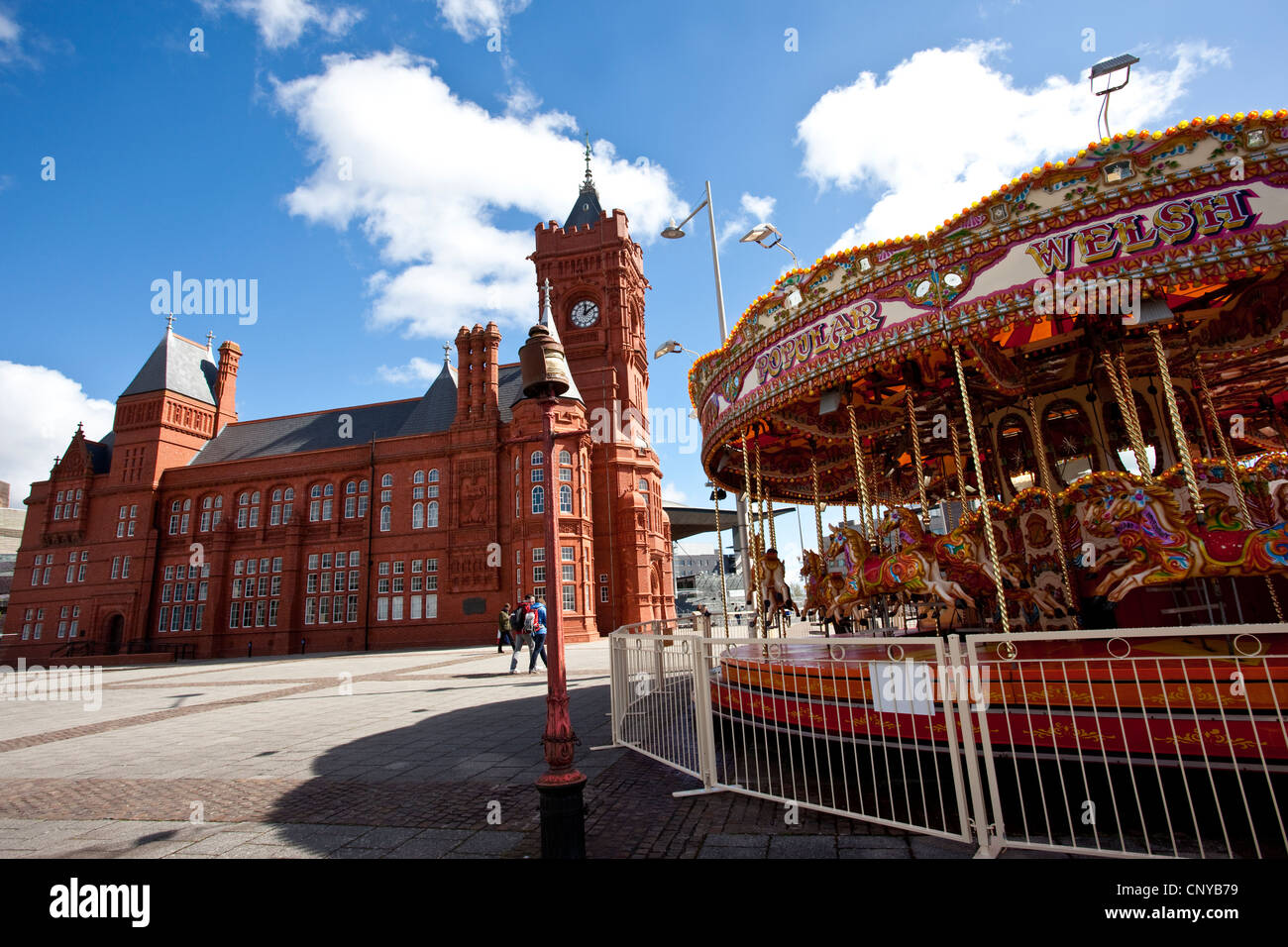 Pierhead building behind a fairground carousel at Cardiff Bay, Wales ...