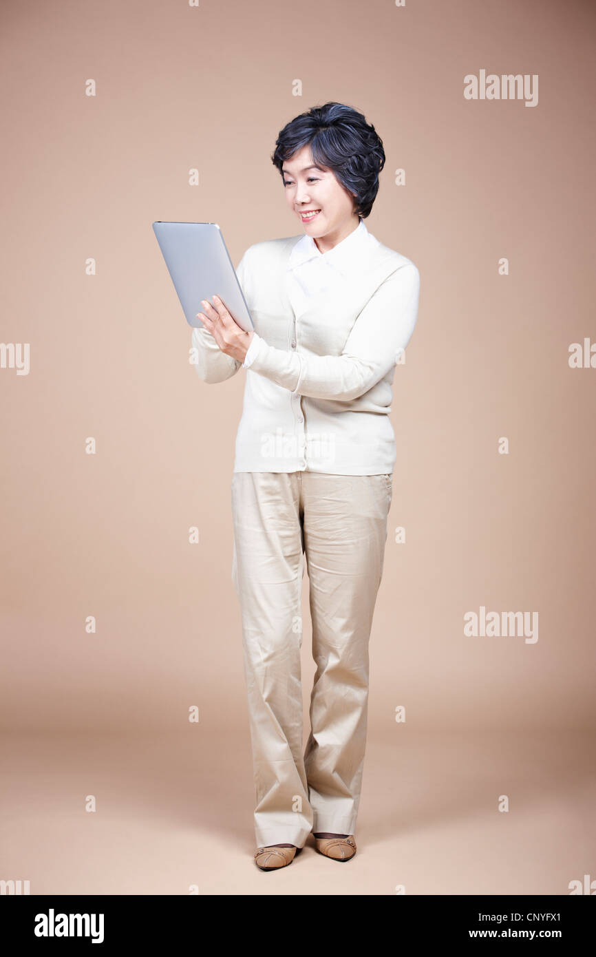 An old woman looking at tablet PC Stock Photo - Alamy