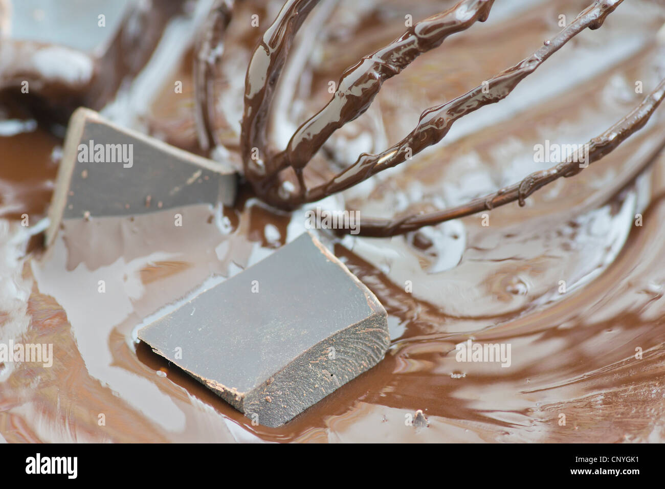 Melting dark chocolate and wire whisk Stock Photo - Alamy