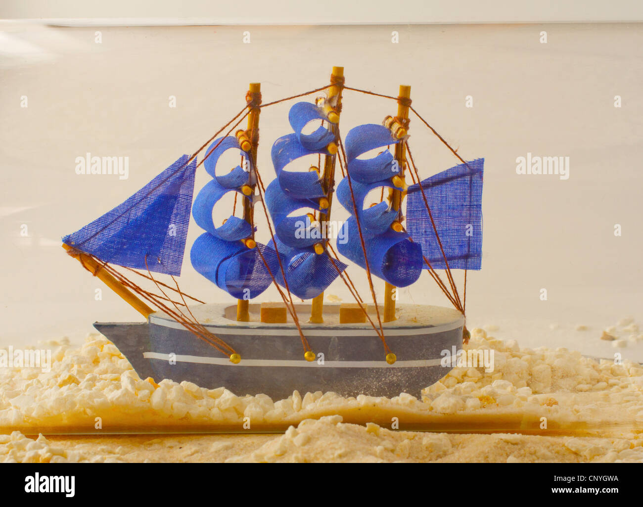 Little ship with blue sails inside a bottle, over sand Stock Photo - Alamy