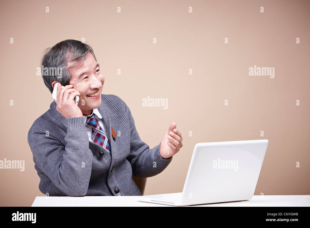 An old man talking on the phone with the laptop around Stock Photo - Alamy