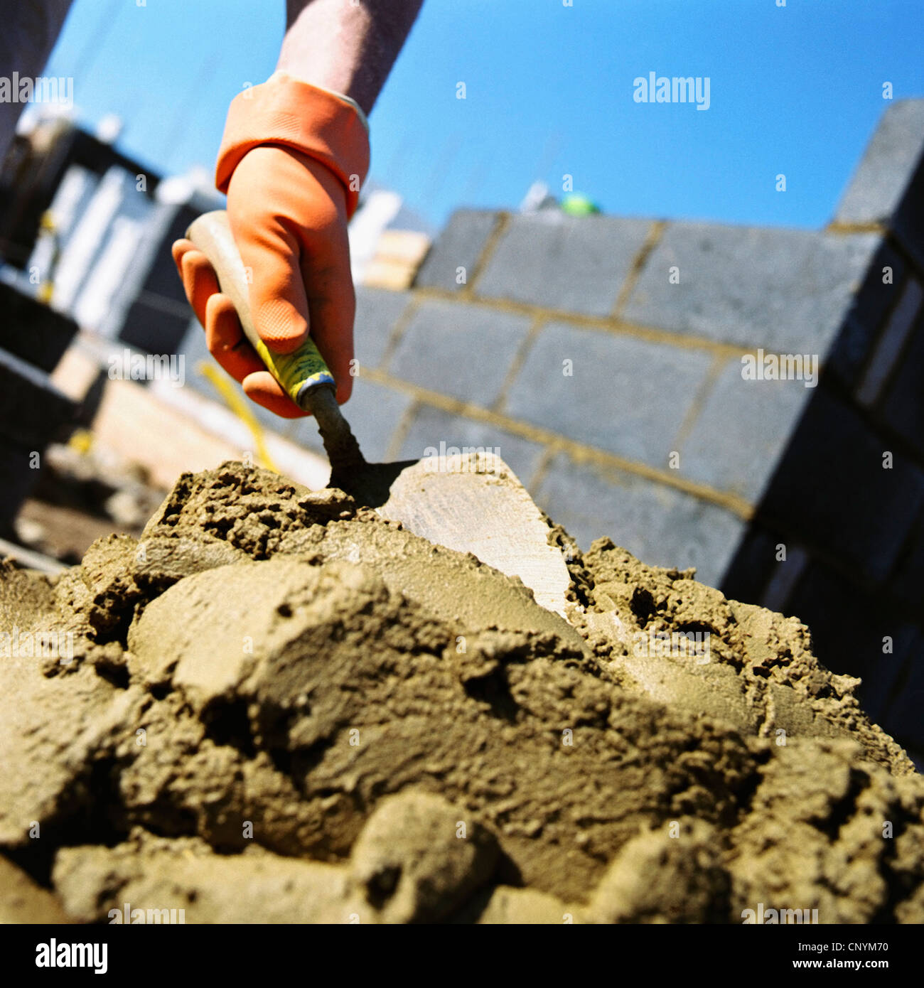 Bricklayer applying cement onto bricks Stock Photo - Alamy