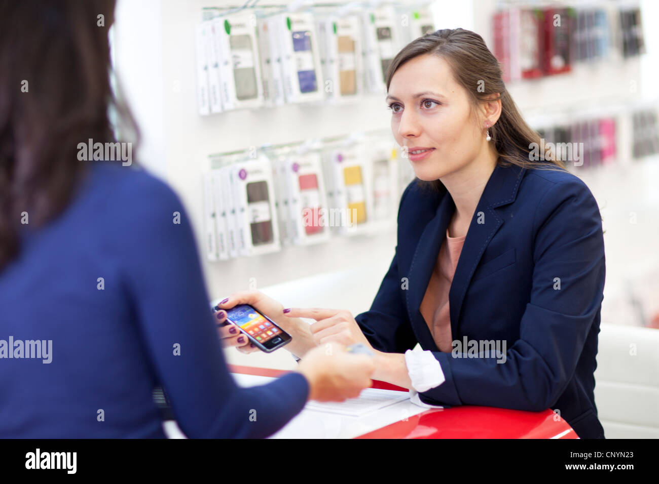 Woman selling a cell phone Stock Photo - Alamy