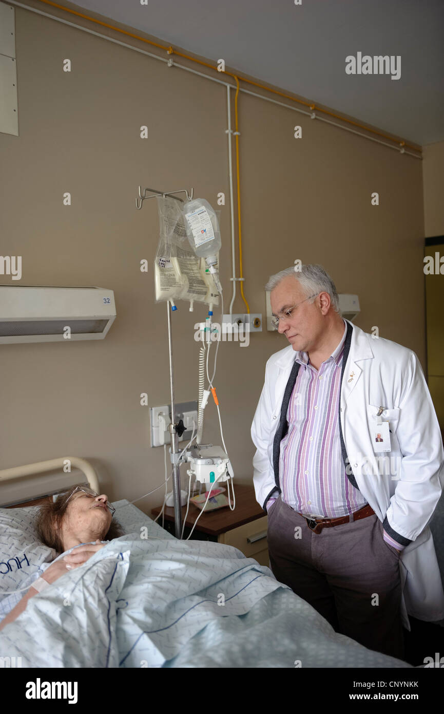 Doctor next to patient's bed in hospital ward Stock Photo - Alamy