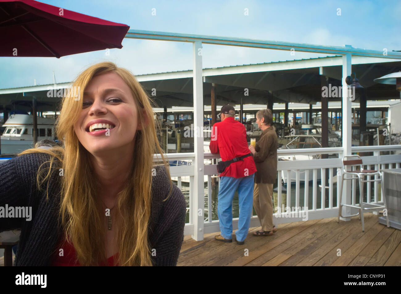 Young blond woman laughing at a marina yacht shipyard at the Texas Gulf ...