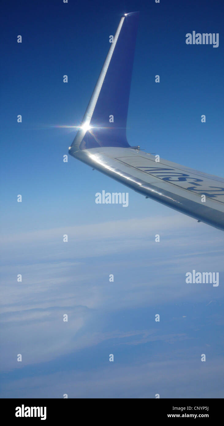 view out of the window of a plane flying high above the clouds on an ...