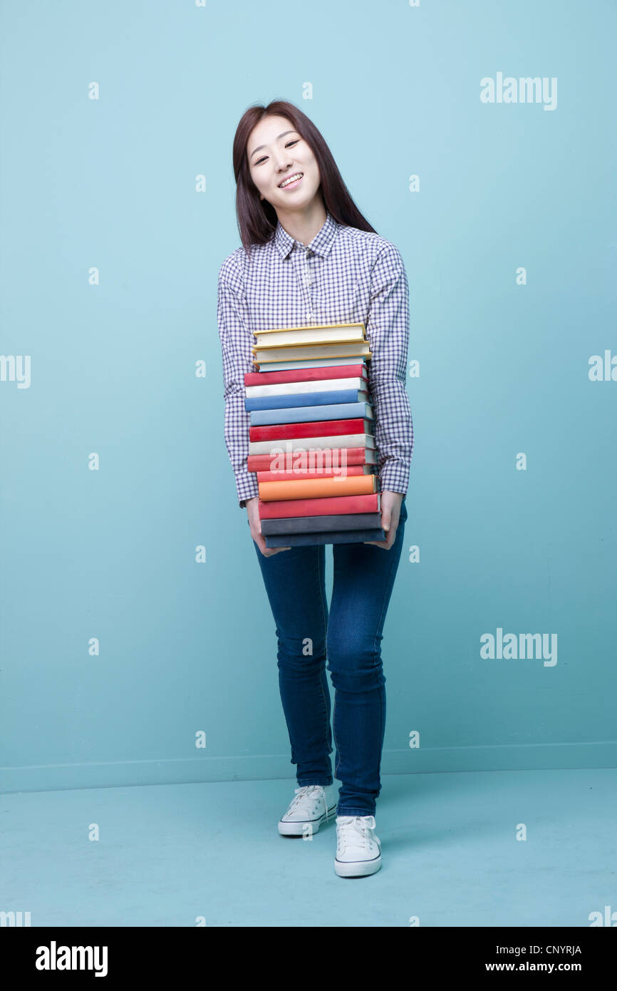 A woman carrying the pile of books Stock Photo - Alamy