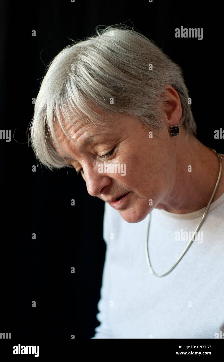 Middle aged woman looking down wistfully Stock Photo - Alamy