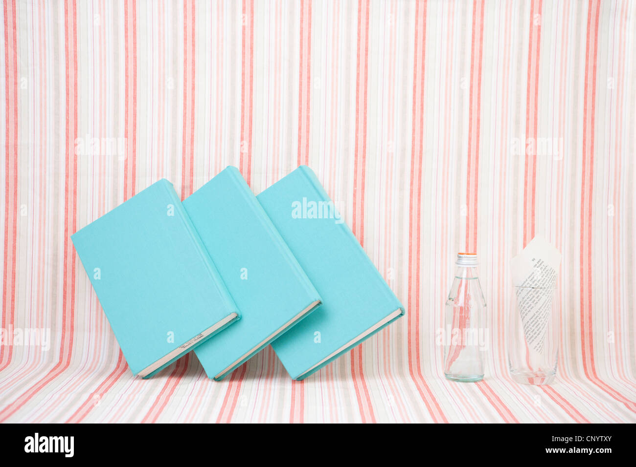 The blue cover book, glass bottle, and paper in glass Stock Photo - Alamy