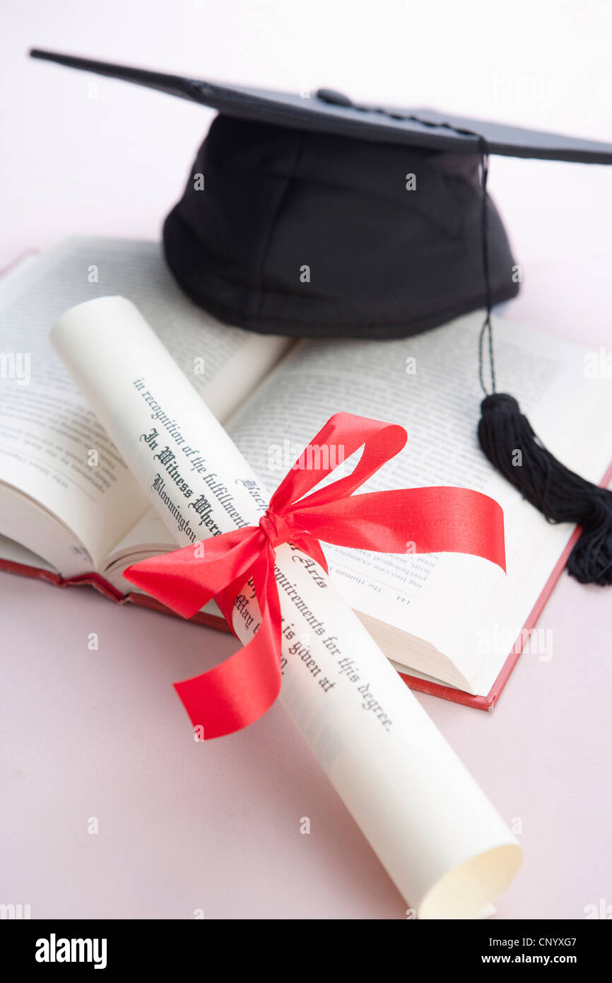 The graduation cap and diploma on the book Stock Photo - Alamy