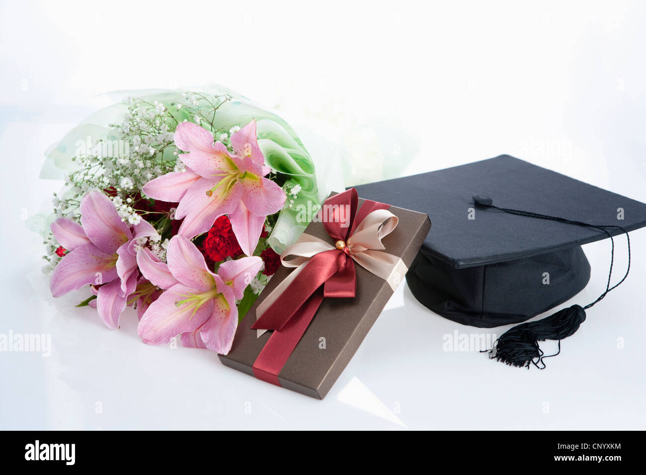 The bouquet of flower, gift, and graduation cap Stock Photo - Alamy