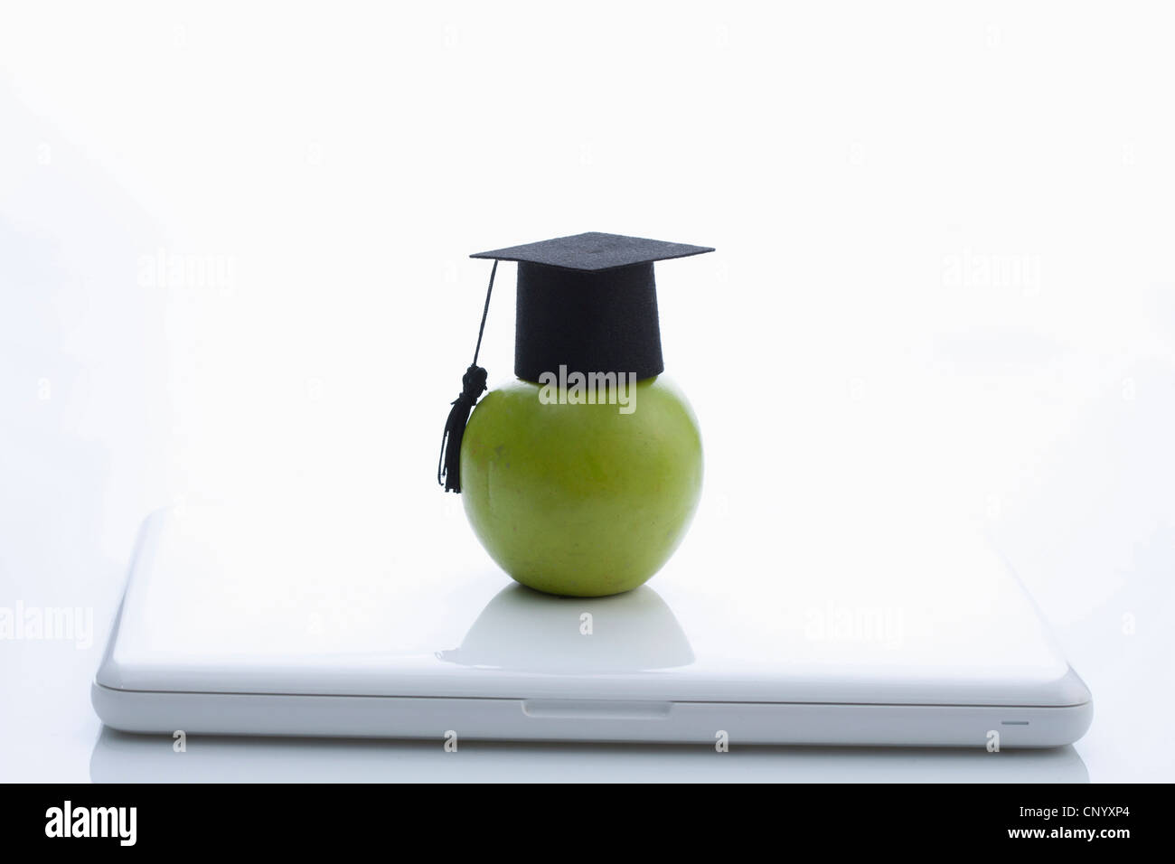 The graduation cap and apple on the laptop Stock Photo - Alamy