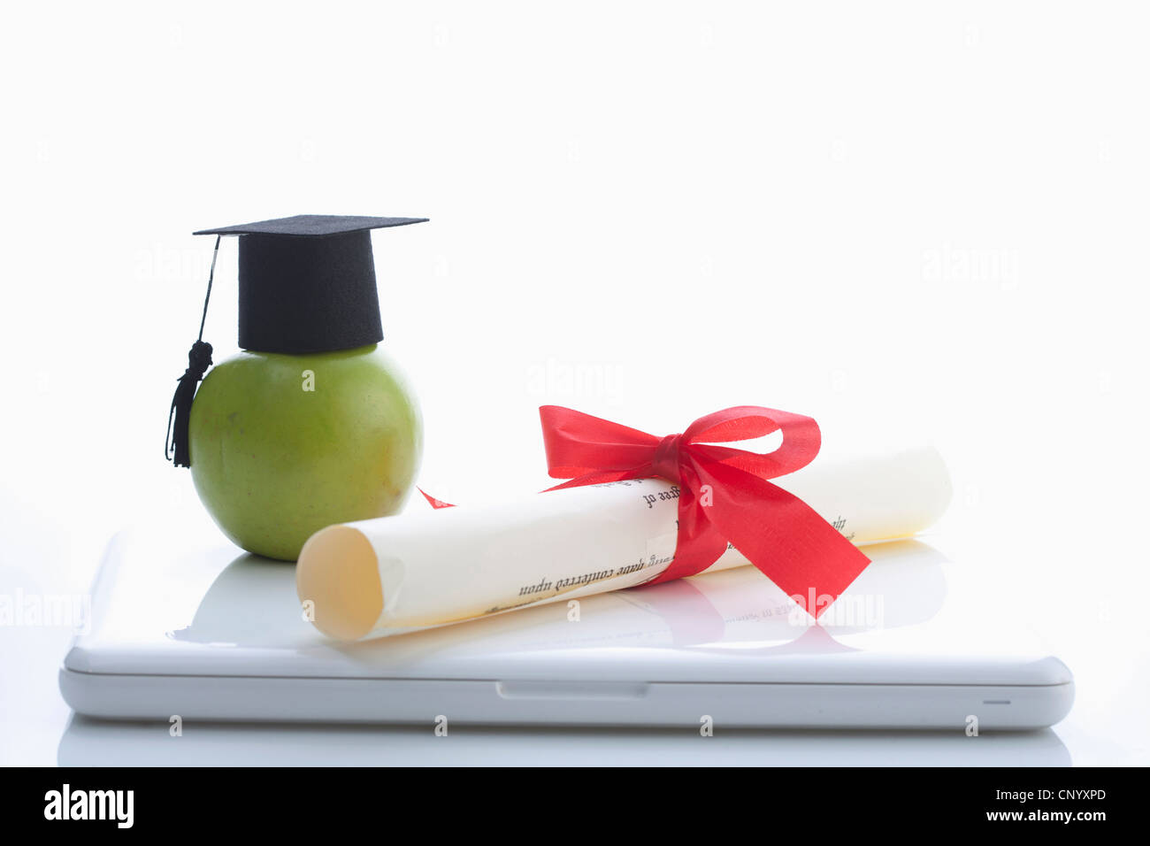 The graduation cap, apple, and diploma on the laptop Stock Photo - Alamy