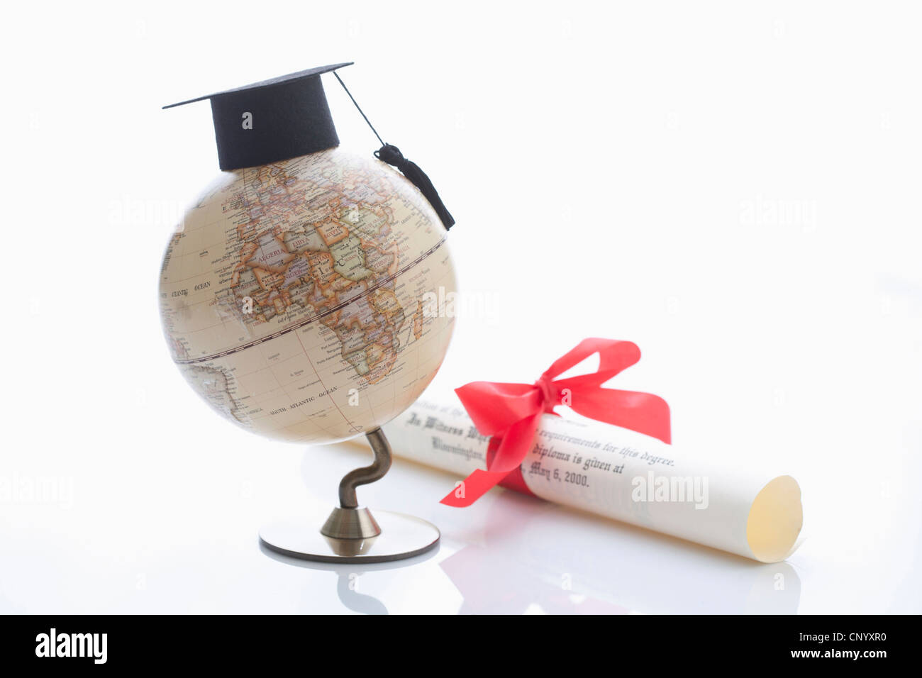 The graduation cap on globe and the diploma Stock Photo - Alamy