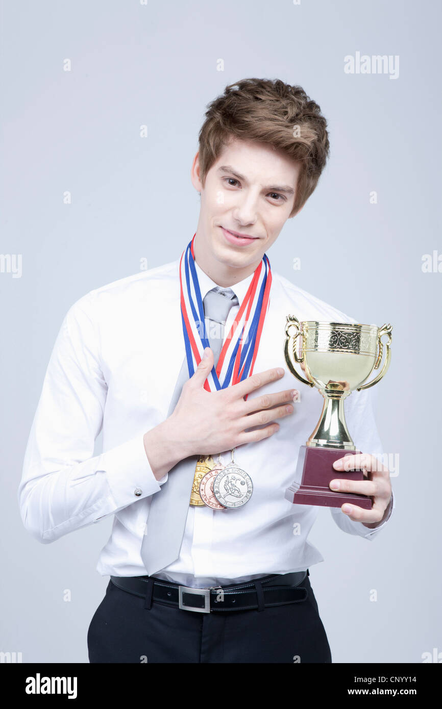 A man holding the prize medal and trophy Stock Photo - Alamy