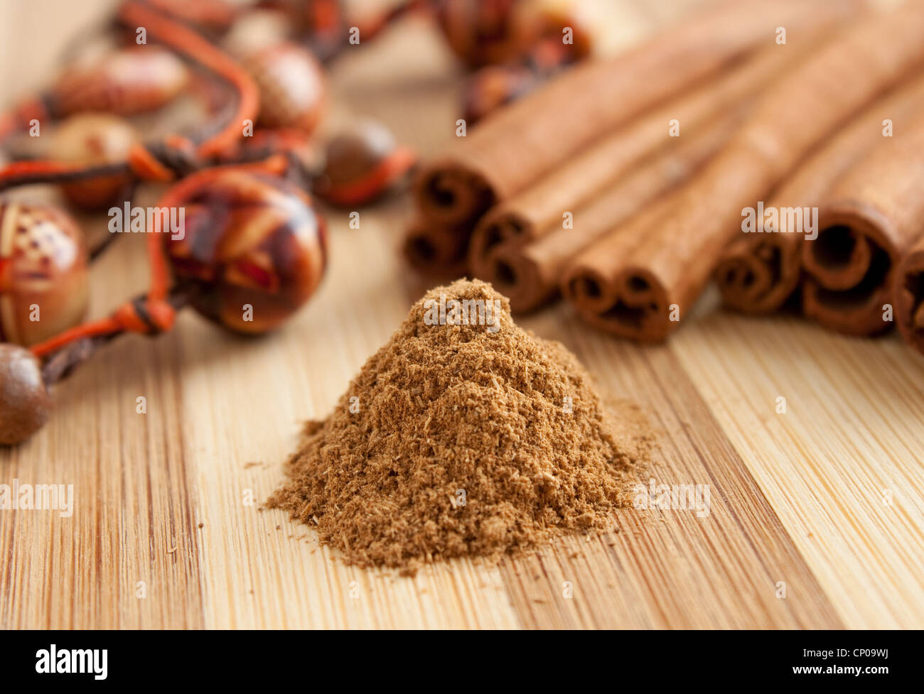 whole cinnamon sticks with a heap of ground cinnamon and ethnic beads ...