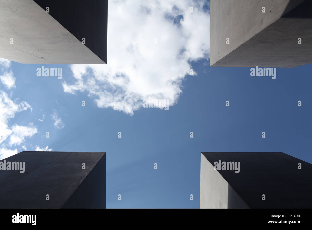 Looking upwards at the sky and clouds past the concrete slabs or stelae ...
