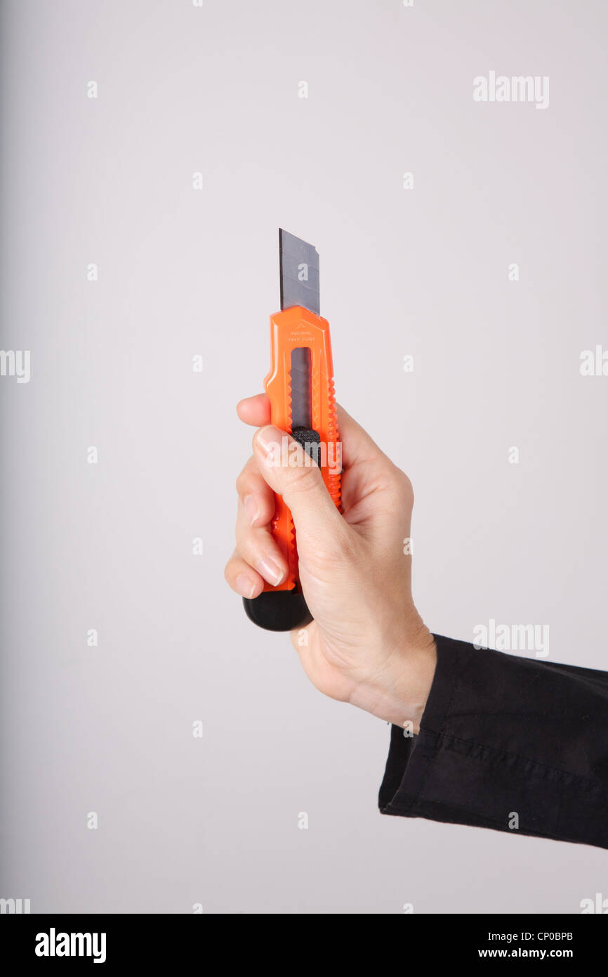 woman hand detail holding an orange cutter Stock Photo - Alamy