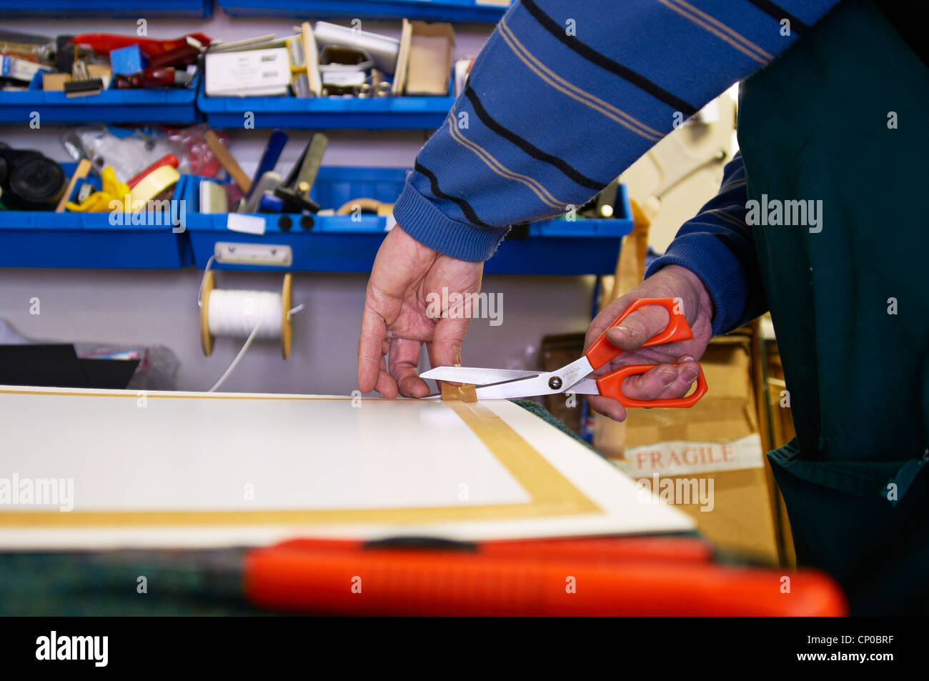 Male using scissors to cut tape Stock Photo - Alamy