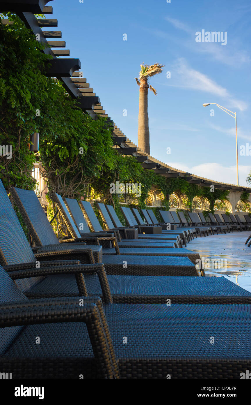 Empty lounges and deck chairs at hotel swimming pool area Stock Photo ...