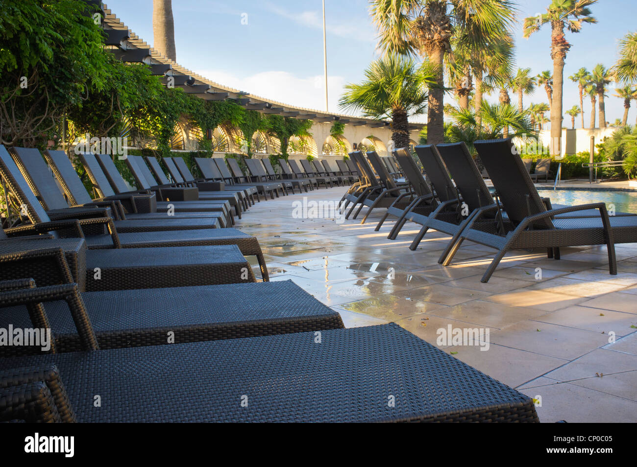 Empty lounges and deck chairs at hotel swimming pool area Stock Photo ...