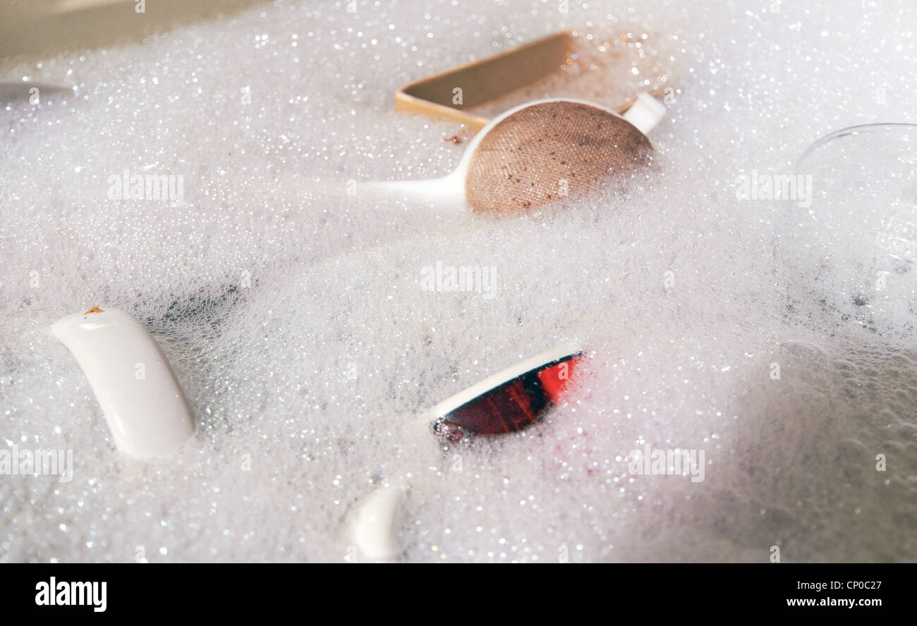 Dishes soaking in soapy water Stock Photo - Alamy