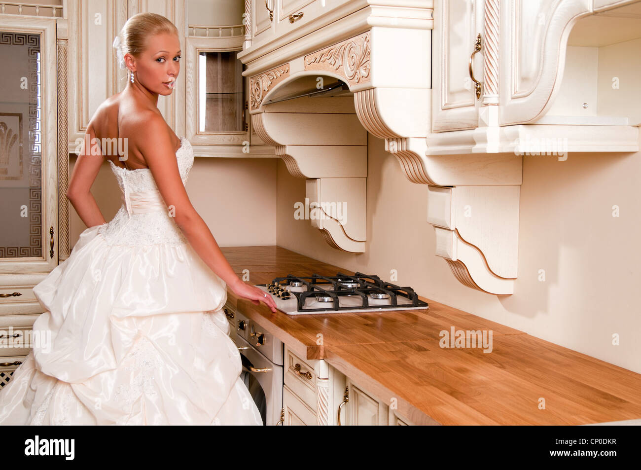 Bride in a luxury dress stands in the kitchen Stock Photo - Alamy