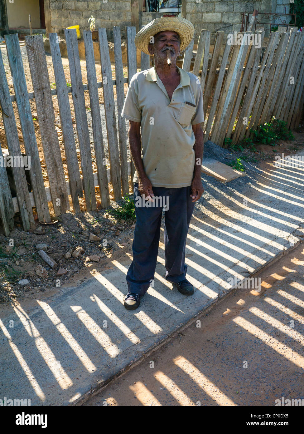 A 60-70 year old Hispanic male stands looking forward and smokes a ...