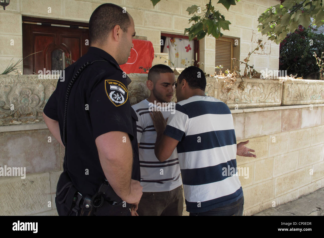 An Israeli policeman in plain clothes questioning a young man in ...