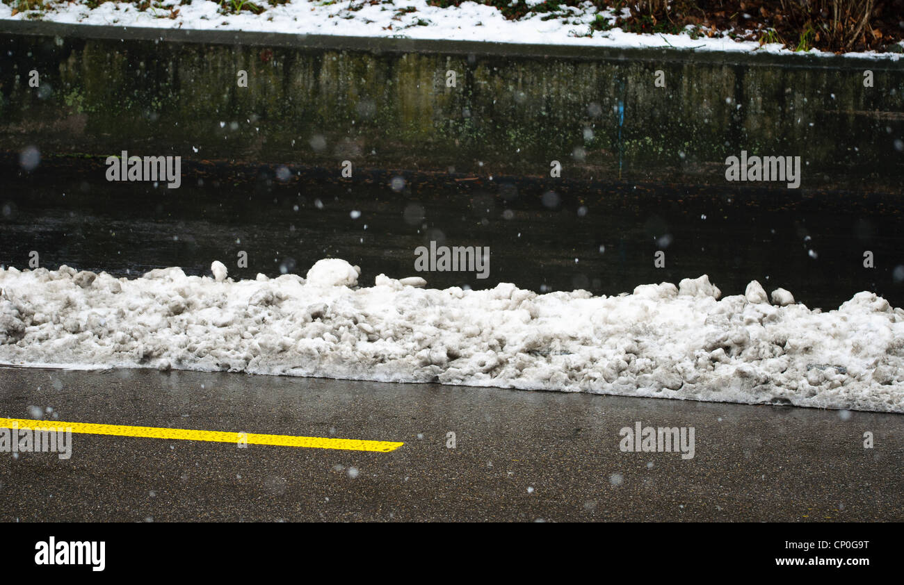 Snowy road side and a yellow traffic line Stock Photo - Alamy
