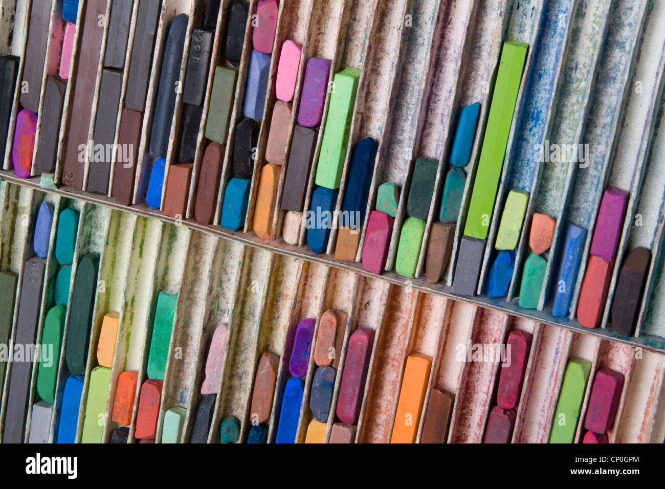 Close-up, angled downward view of large box of used, colored artist ...