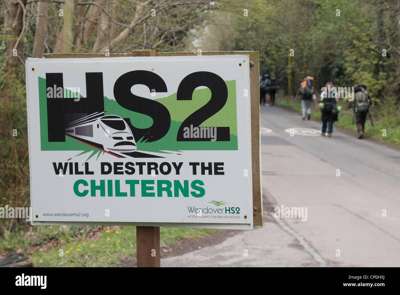 Walkers past by an anti High Speed 2 (HS2-proposed railway) poster (Apr ...