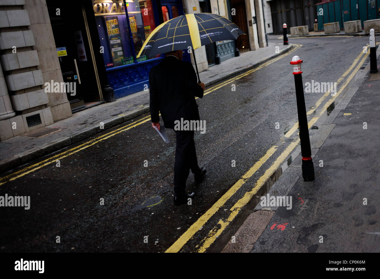 Businessman walks down quiet financial district back street carrying an ...