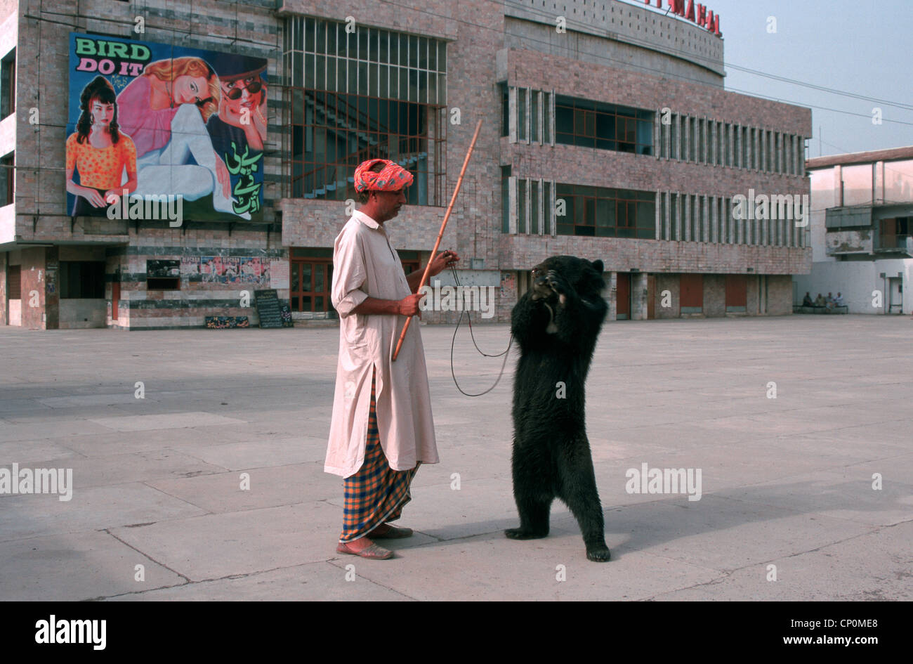 Bear tamer in front of a cinema hall ( Pakistan Stock Photo - Alamy