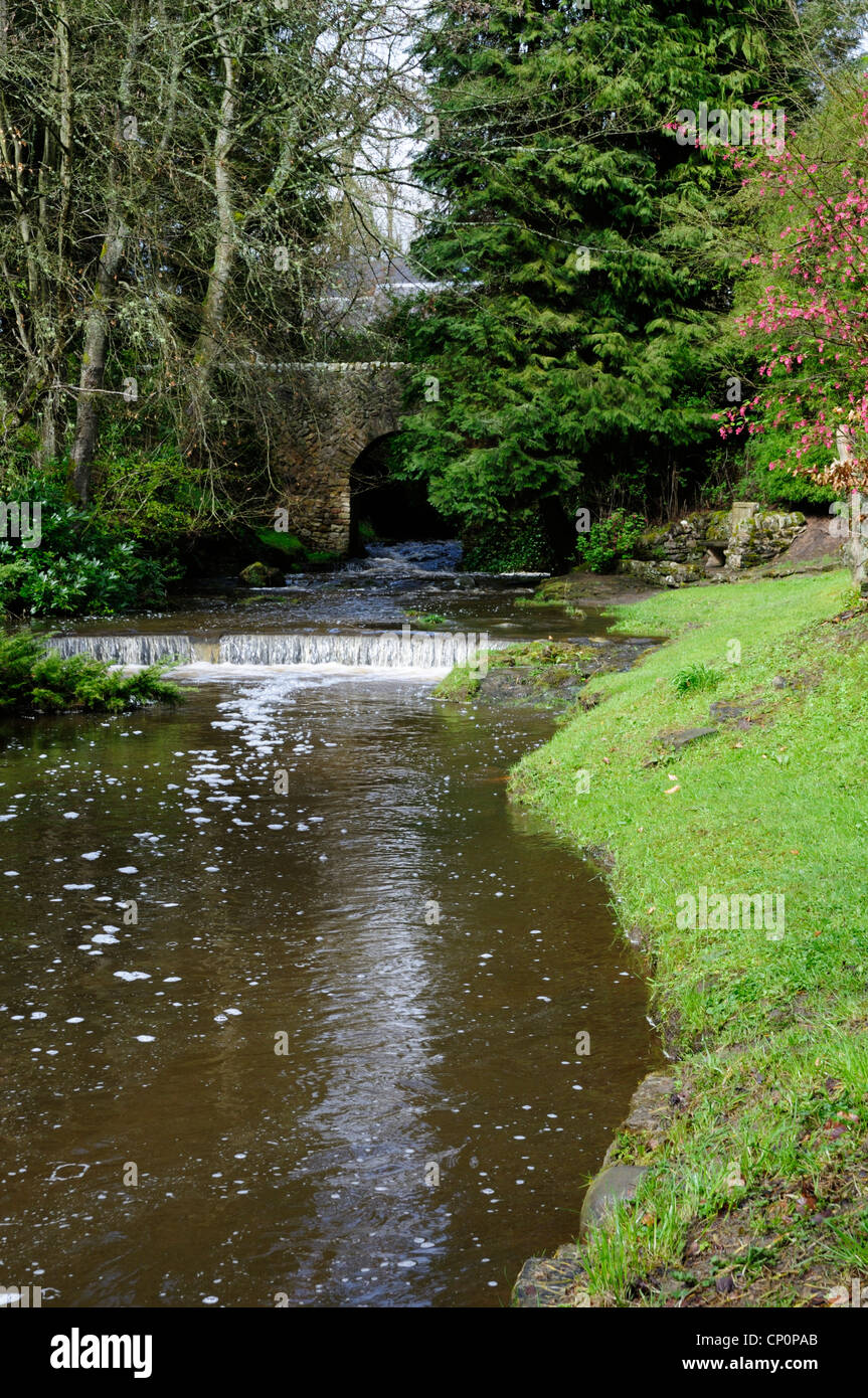 River flowing under bridge and over weir Stock Photo - Alamy